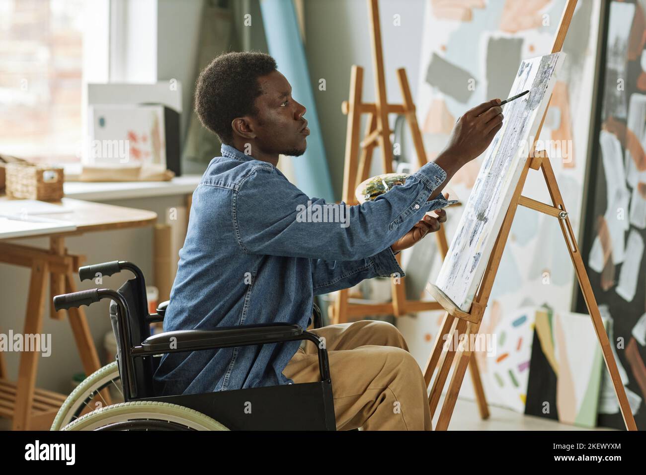 Young man with disability painting masterpiece on canvas with acrylic ...