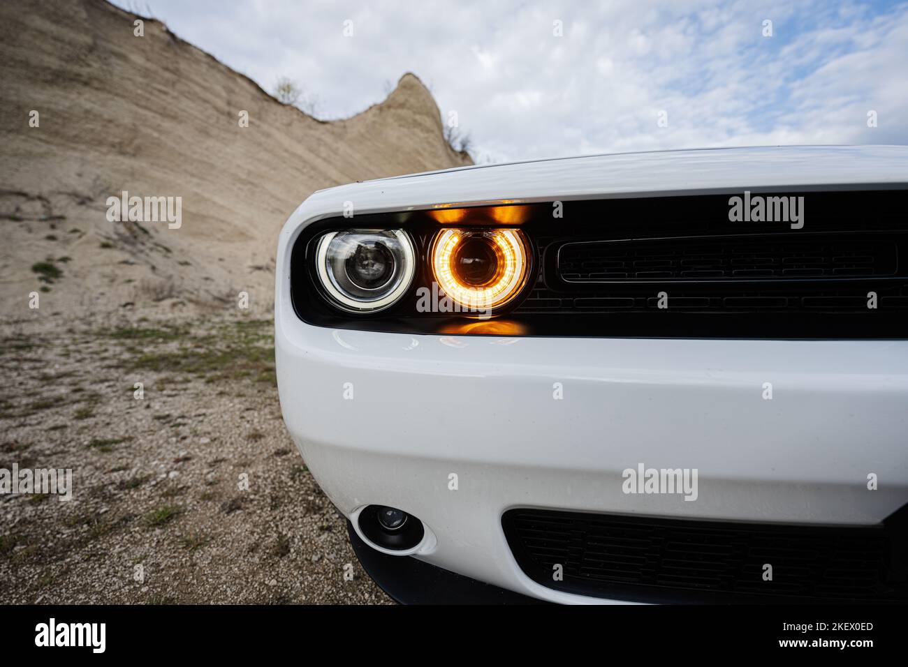 Round headlights of white powerfull american muscle car in career Stock ...