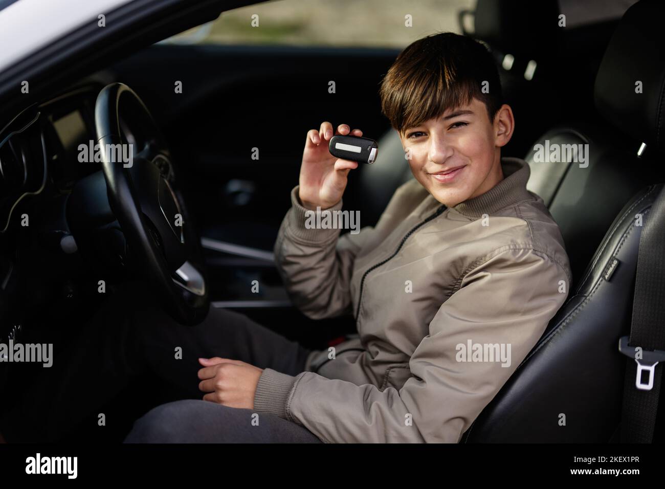 Teenager boy sit in muscle car. Young teen driver showing keys Stock ...