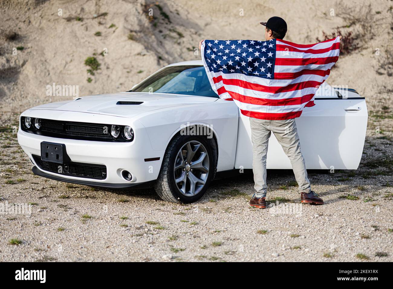 Back of man with USA flag near his white american muscle car in career ...