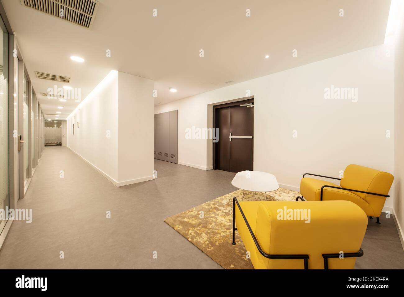 Long corridors of a coworking office with cubicles and glass partitions ...