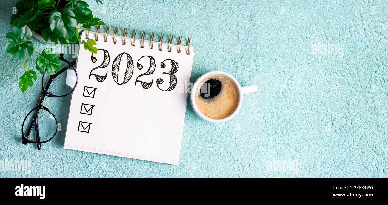 New year goals 2023 on desk. 2023 goals list with notebook, coffee cup ...