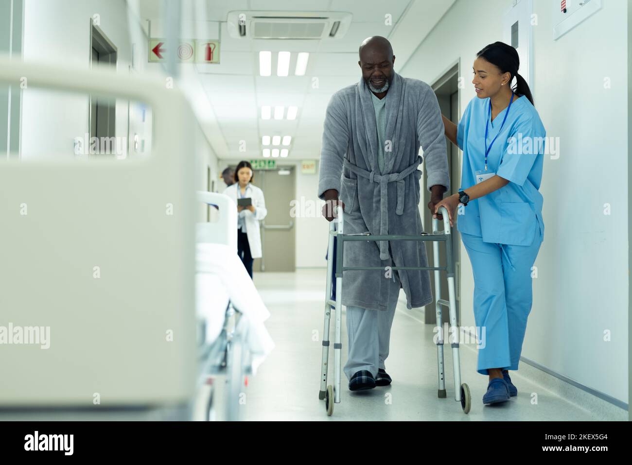 Diverse female healthcare worker helping senior african american male ...