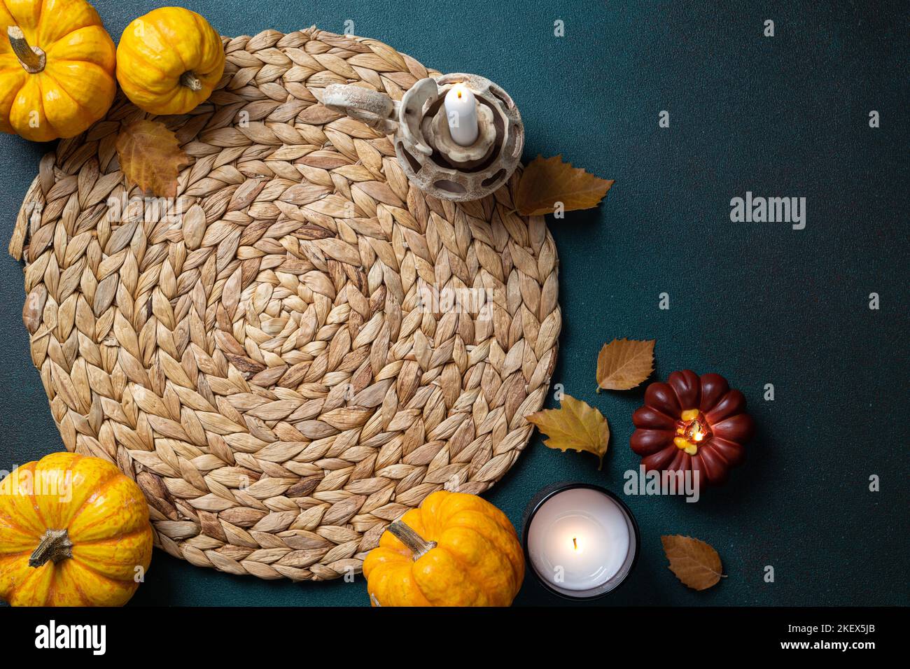 Autumn hygge cozy table setting. Top view of wicker place mat, pumpkins ...