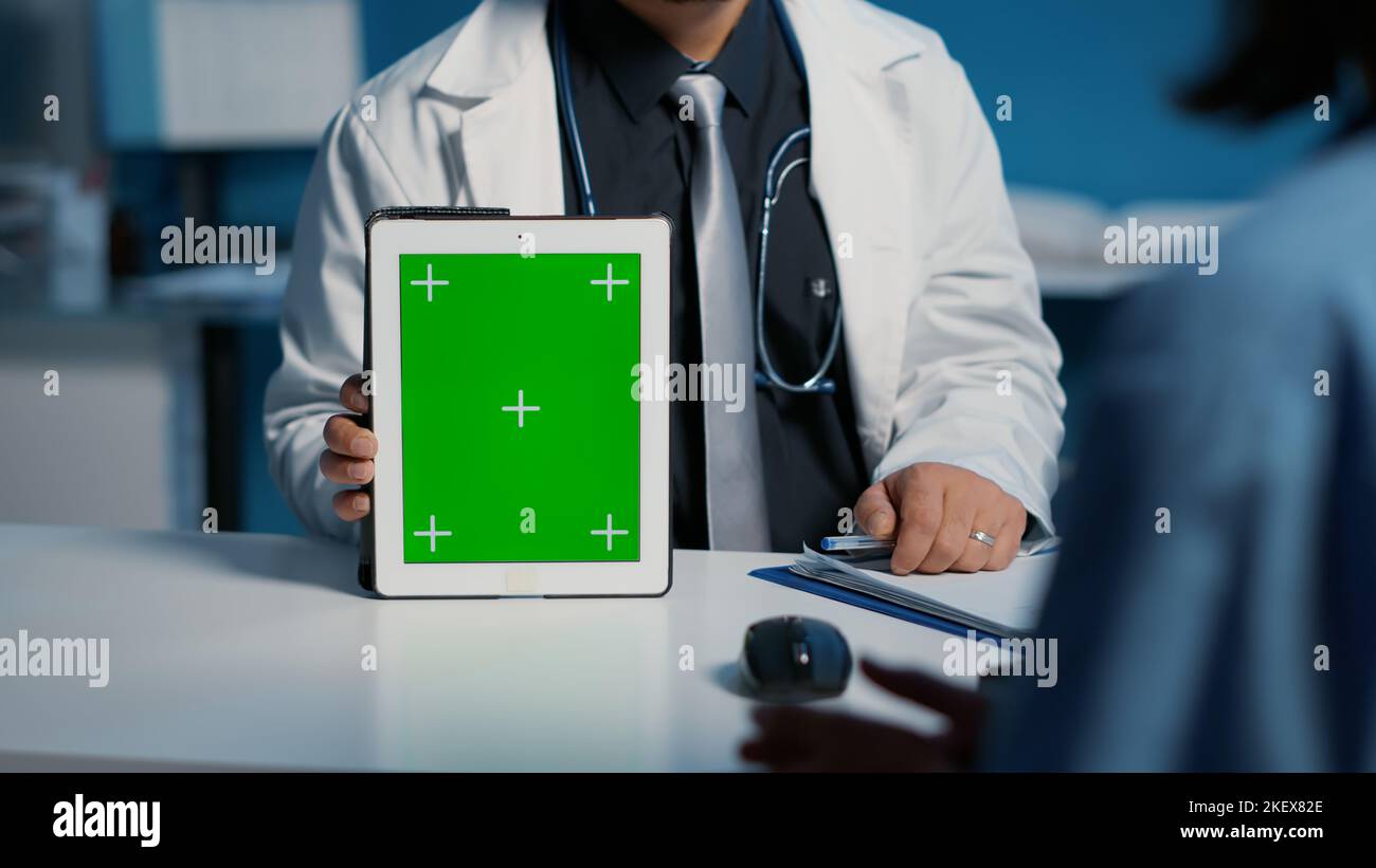 Practitioner doctor holding tablet computer pointing at green screen ...