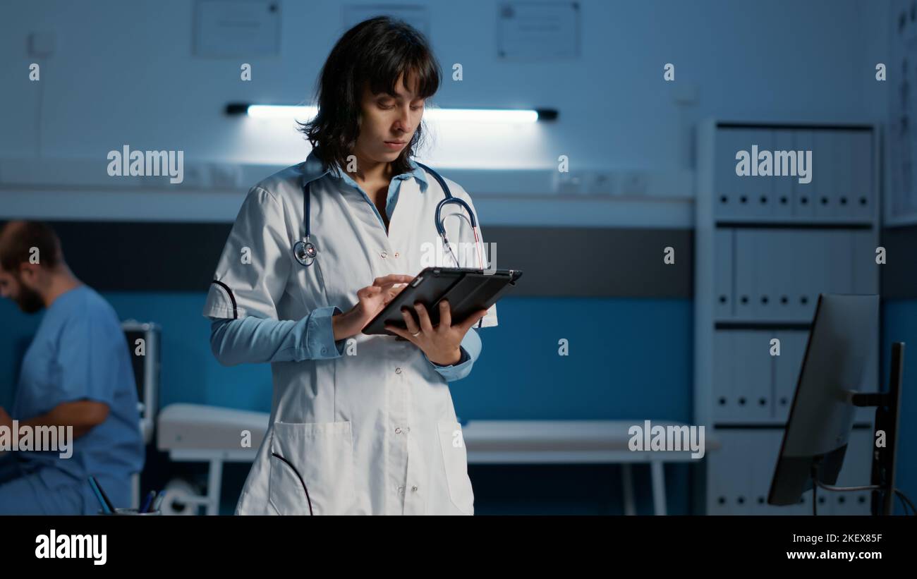 Practitioner doctor holding tablet computer checking patient report ...