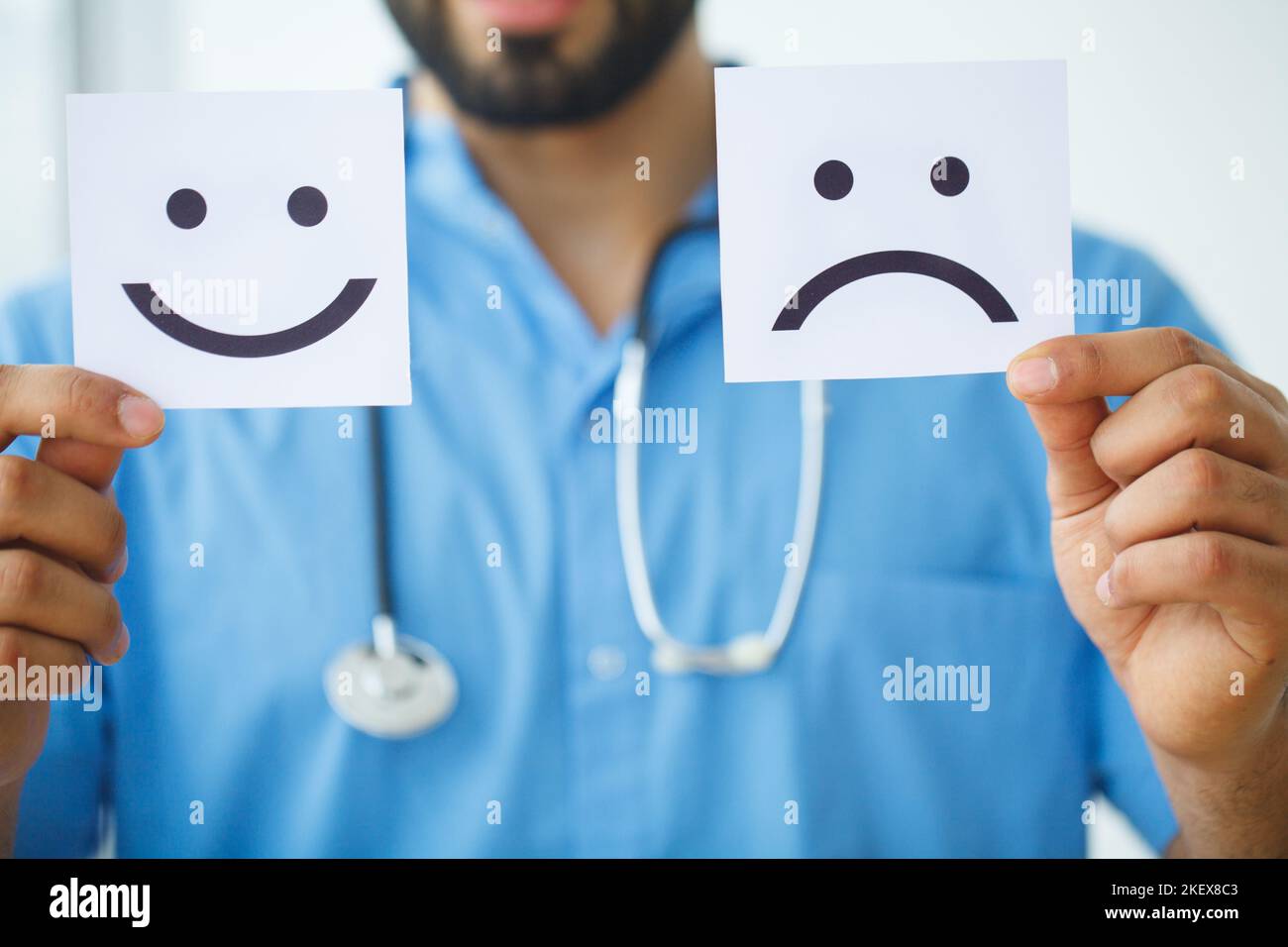 Health Care. Doctor Holding a Cards With Symbol Fun and Sad Smile ...