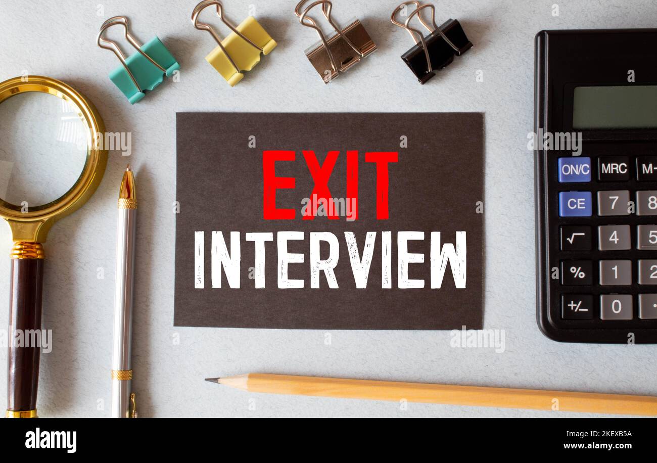 Business concept.Text EXIT INTERVIEW writing on notepaper with pen and ...