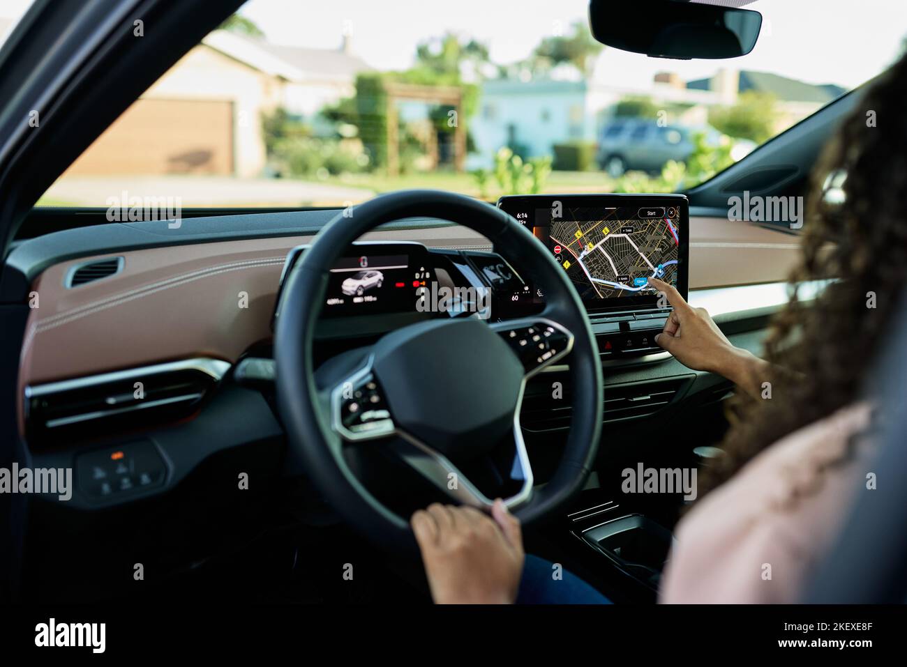 Woman holding steering wheel using GPS system in electric car Stock ...