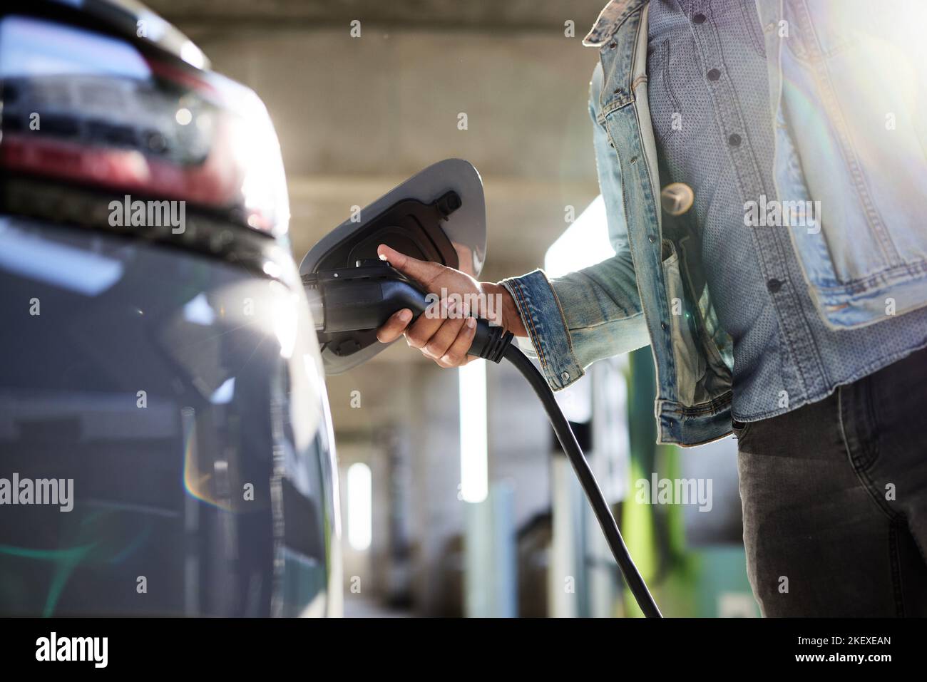 Midsection of man plugging in cable while charging electric car Stock ...