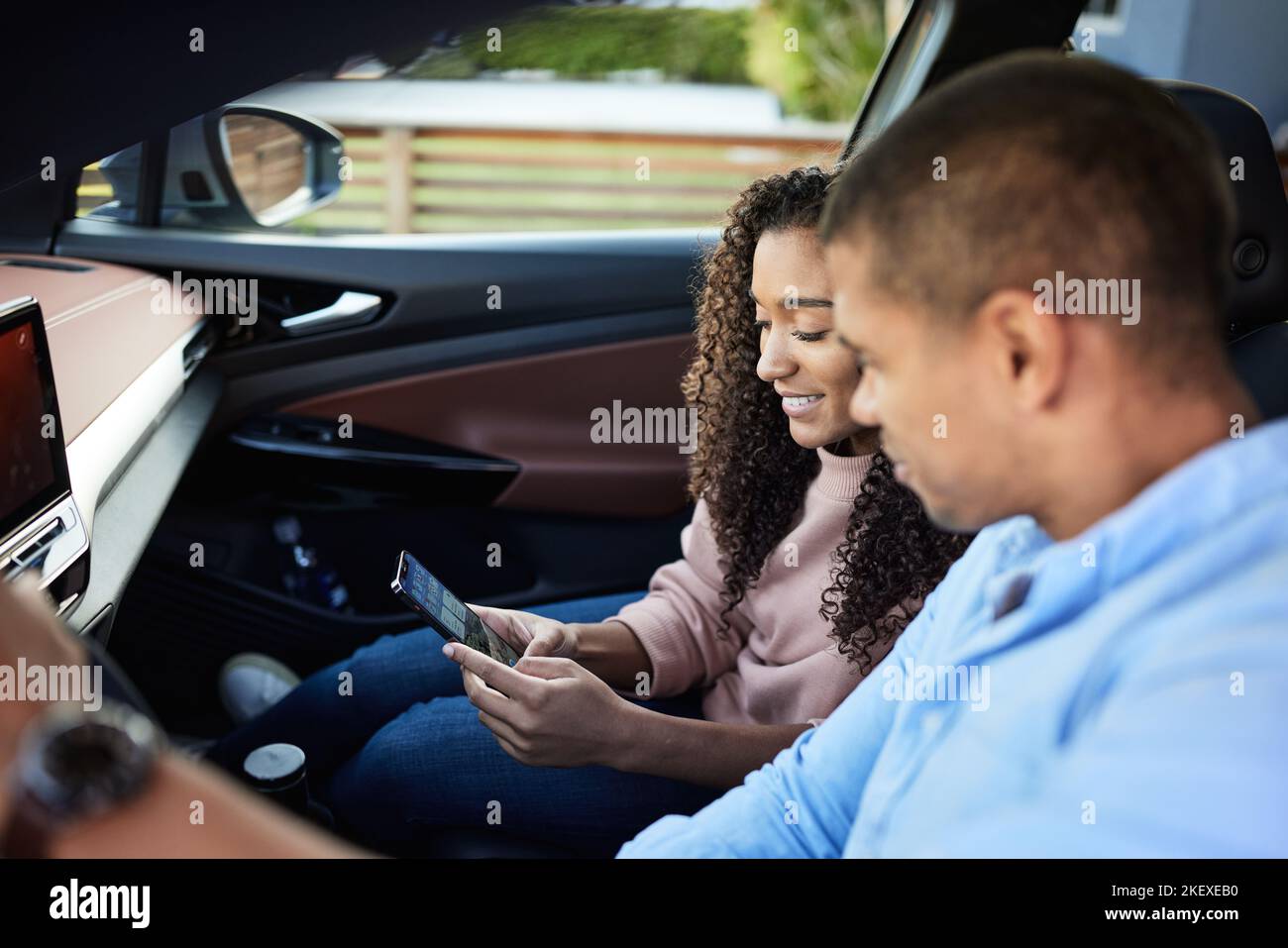Woman sharing mobile phone with boyfriend sitting in car Stock Photo ...