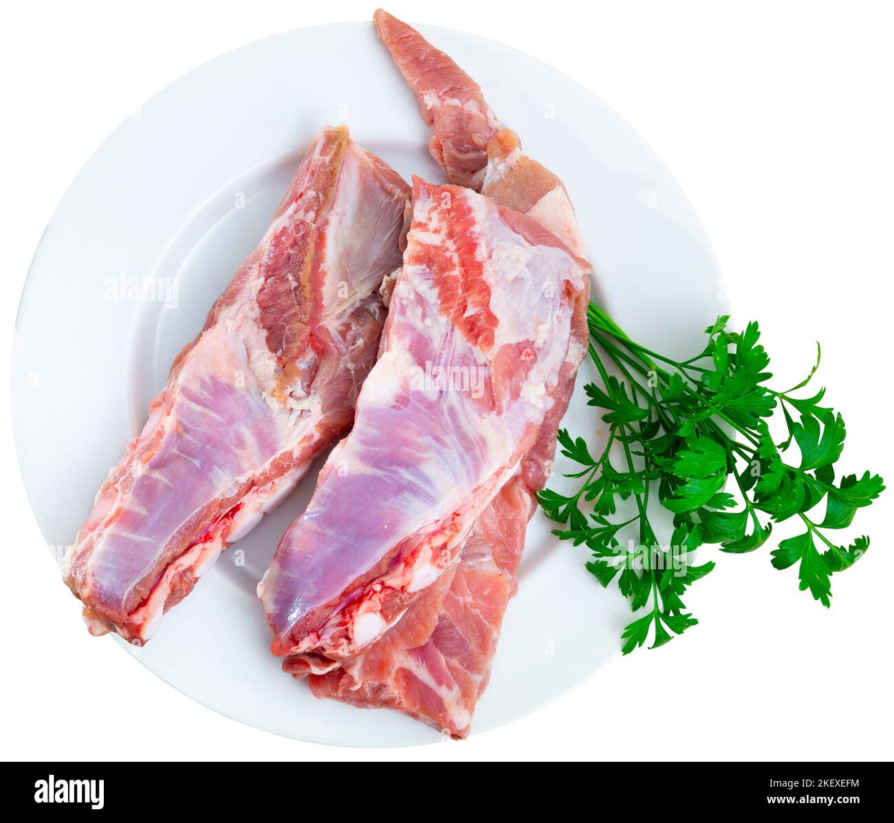 Raw meaty pork ribs slabs on plate with fresh greens Stock Photo - Alamy