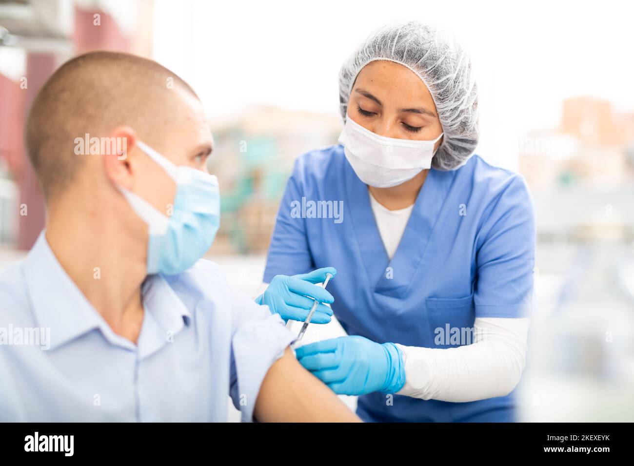 doctor in a protective face mask makes vaccination Stock Photo - Alamy