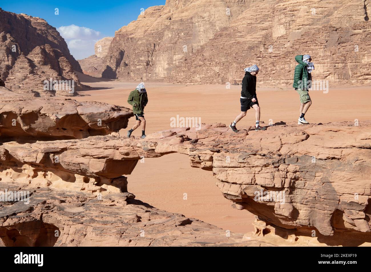 Three tourists crossing rock bridge Wadi Rum Jordan Stock Photo - Alamy