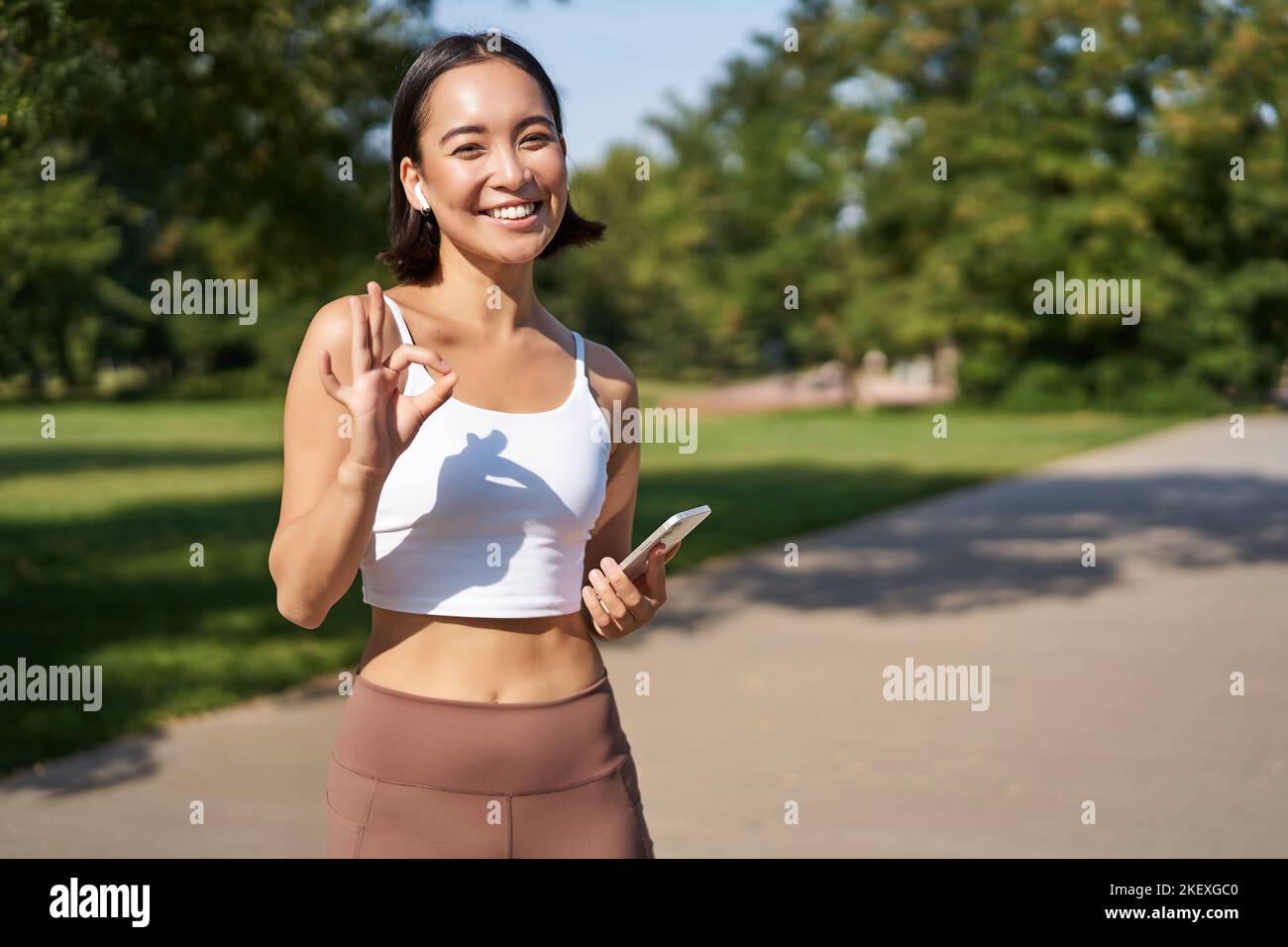Sport people. Happy asian girl, sportswoman showing okay sign and ...