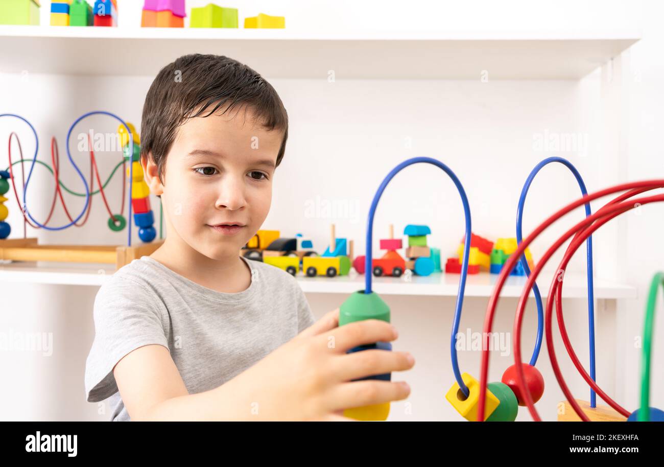 Shot of adorable little boy playing with roller coaster maze toy skill ...