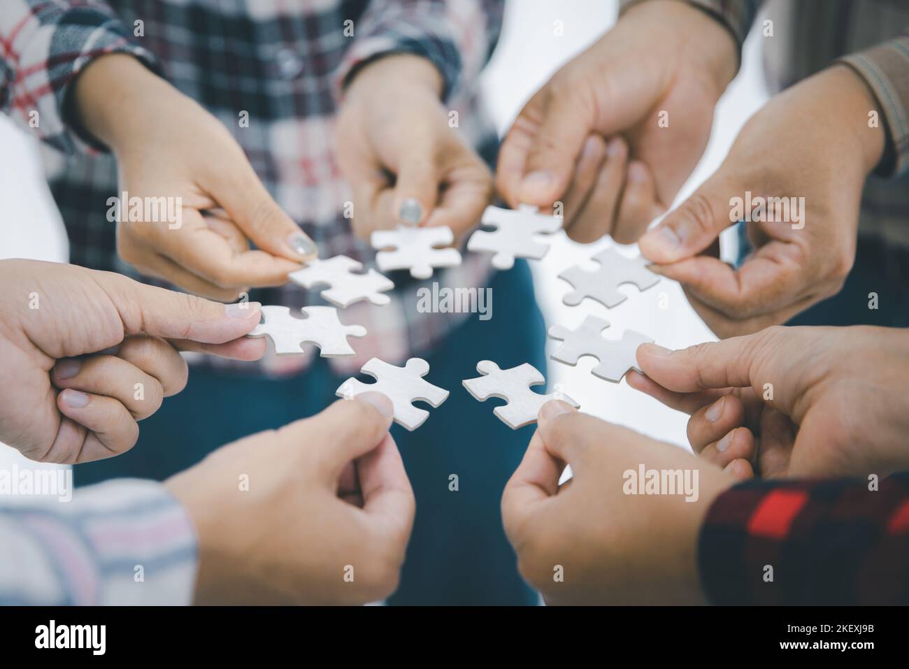 Concept of finding solution. close up people assembling jigsaw puzzles ...