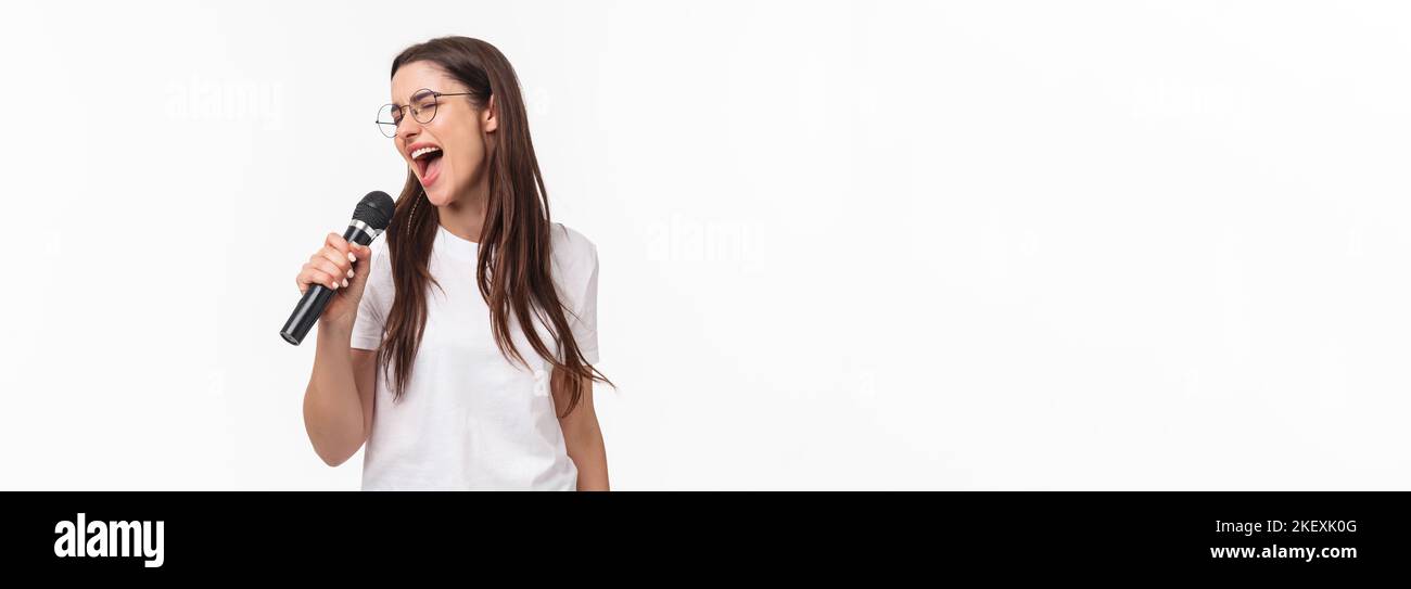 Carefree happy and relaxed young woman singing her heart out ...