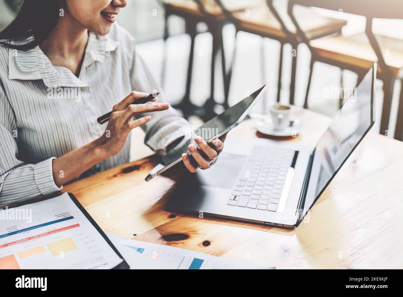 Portrait of an Asian female employee using a tablet computer at work ...