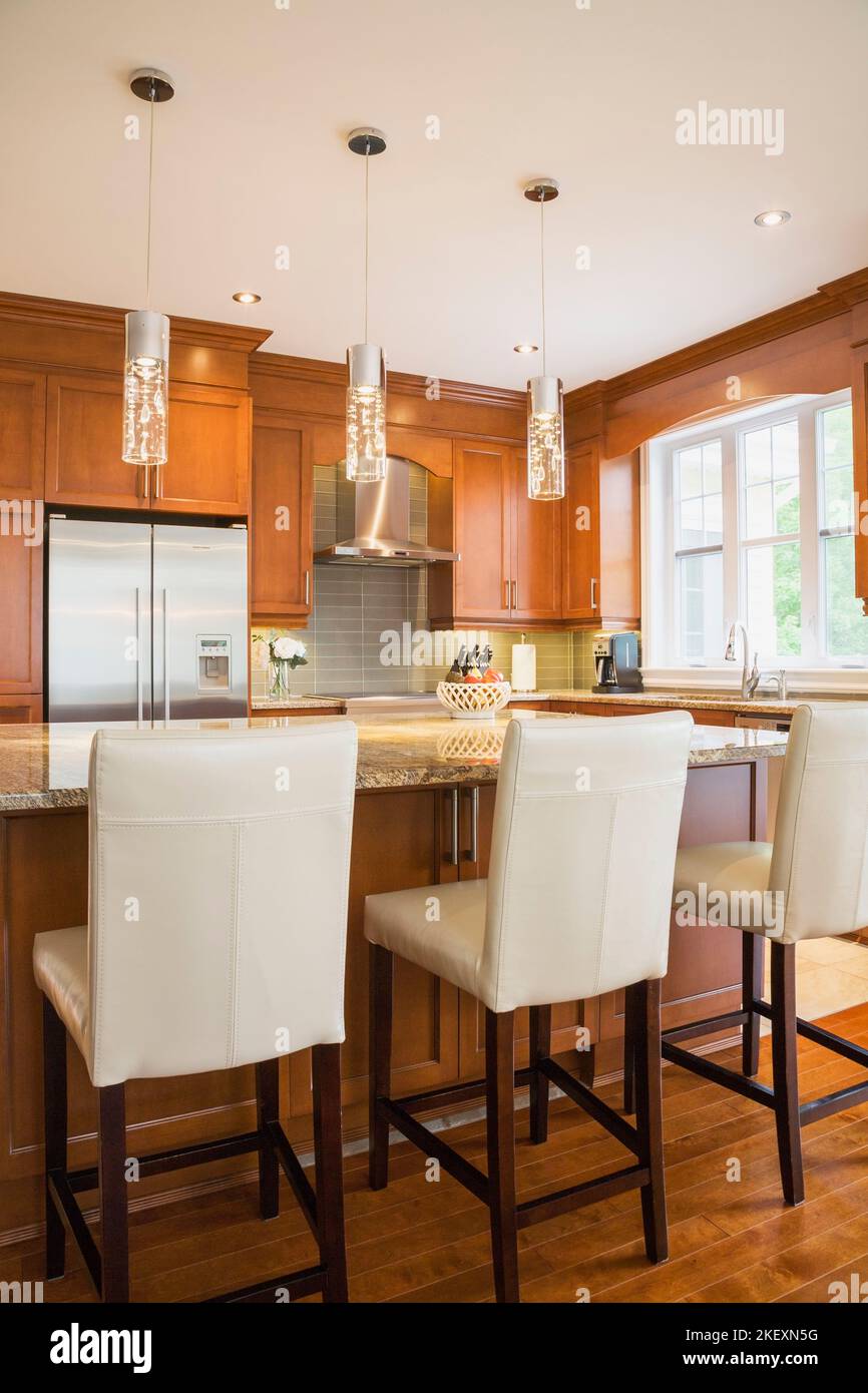 White high-back leather and wood chairs and stained cherry wood island ...