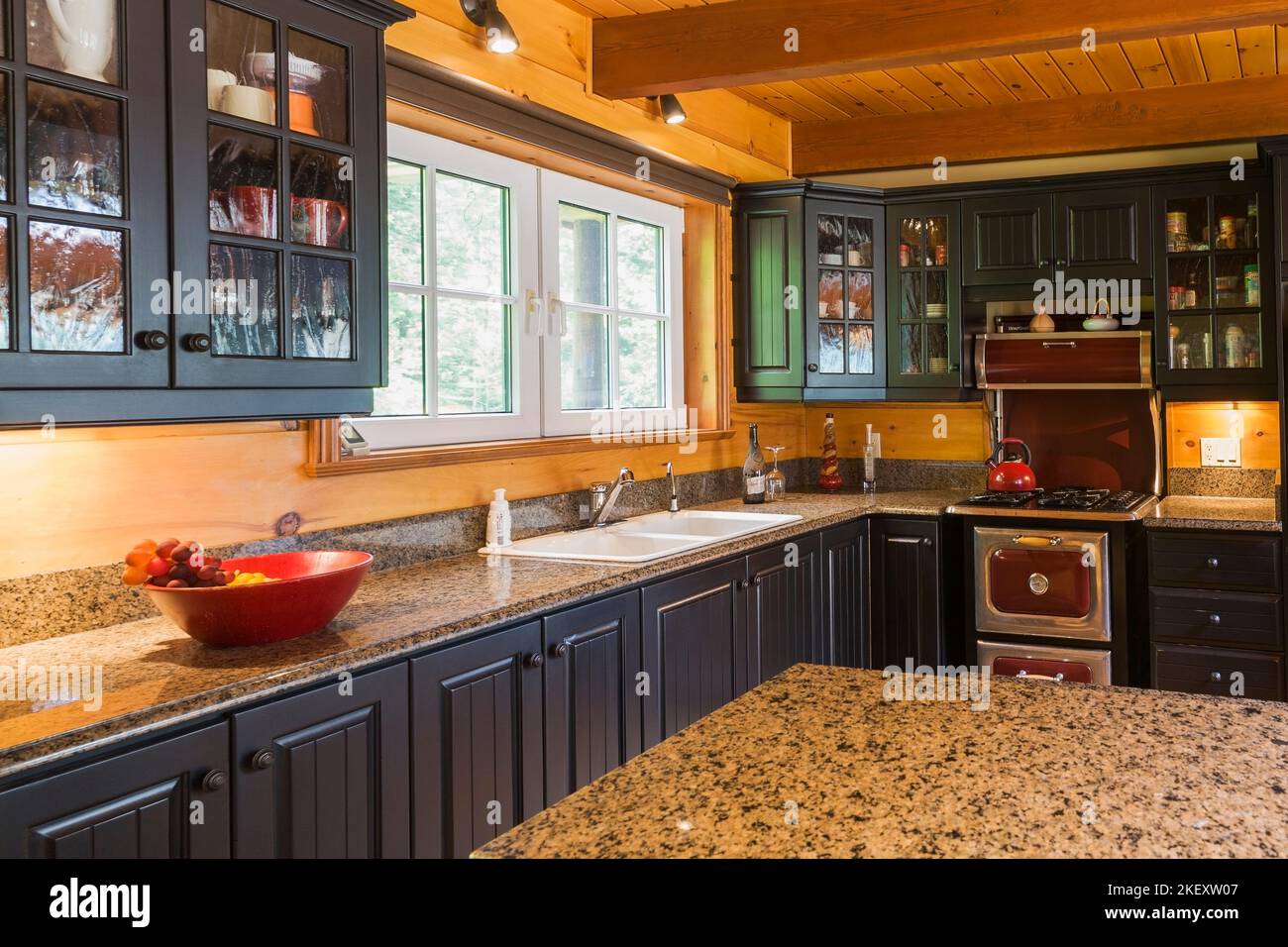 Kitchen with black wooden cabinets, antique cooking stove and granite ...
