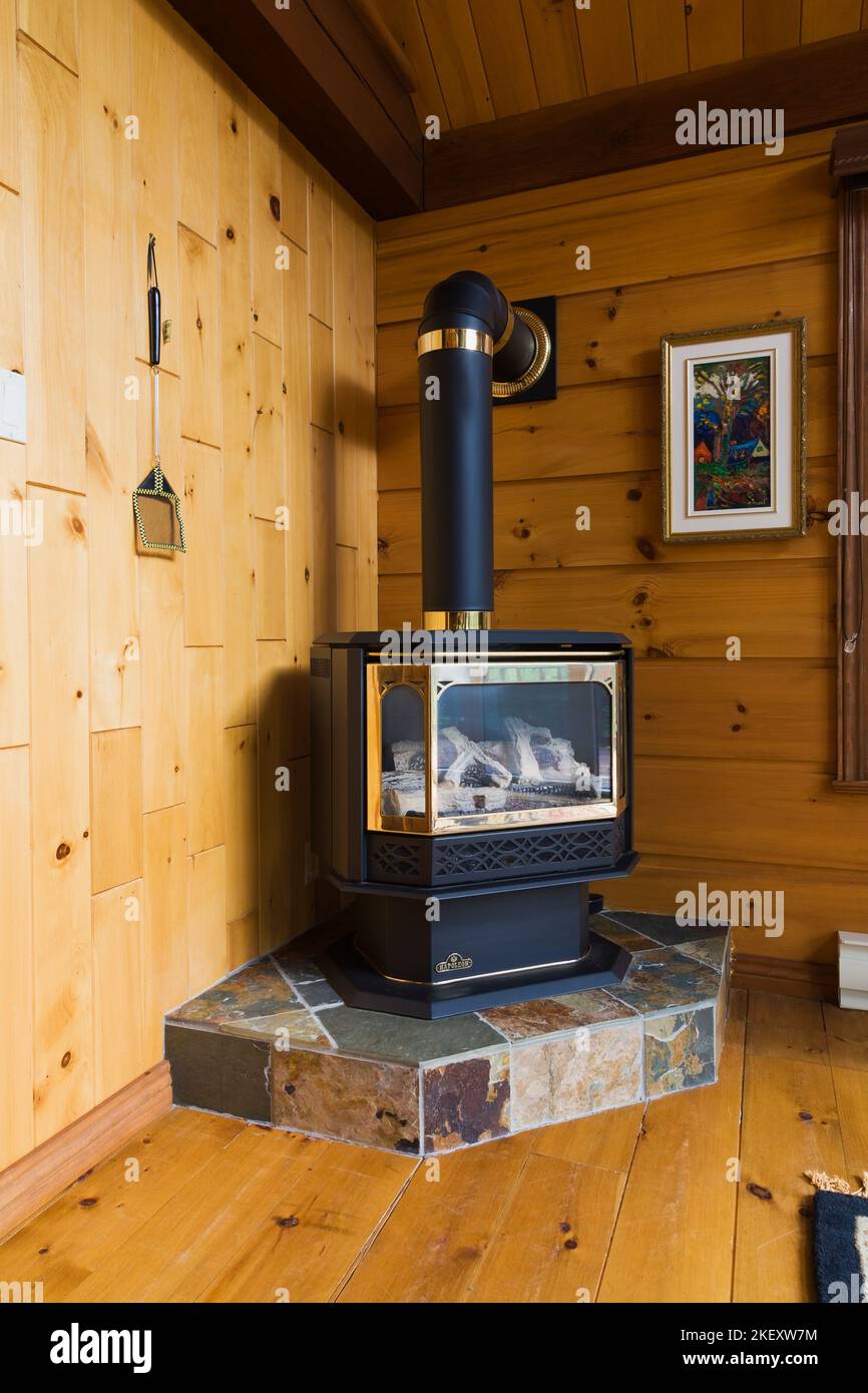 Gas fireplace on elevated natural stone base in a corner of living room ...