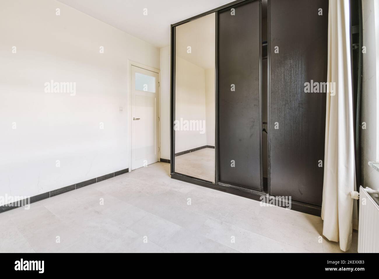 Plastic window and radiator on white wall in empty light room at home ...