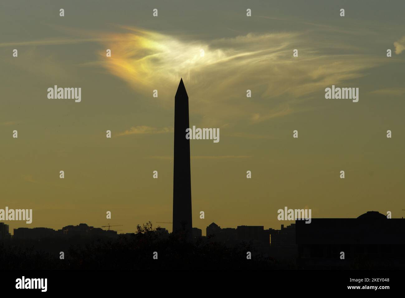 A colorful, rainbow-like sundog hangs in a cirrus cloud above the ...