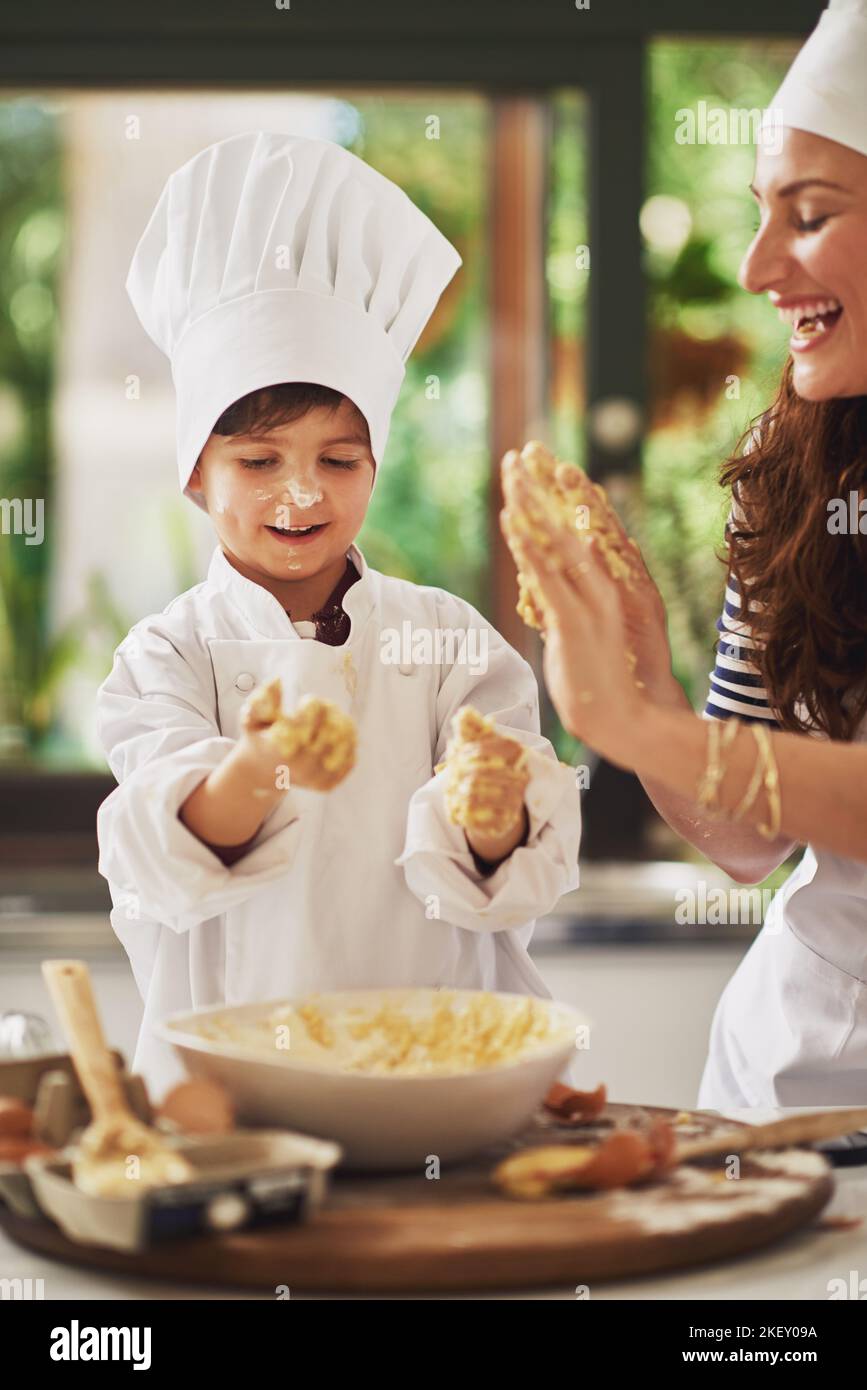 Its messy work but its worth it. a mother and her young son with dough ...