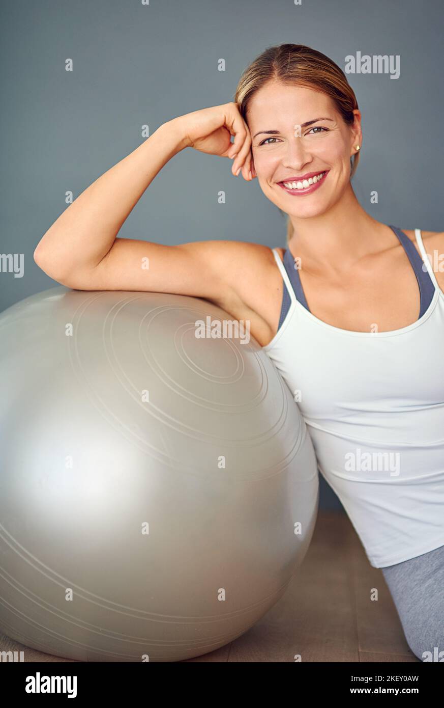 Have a ball. a sporty young woman sitting next to her fitness ball ...