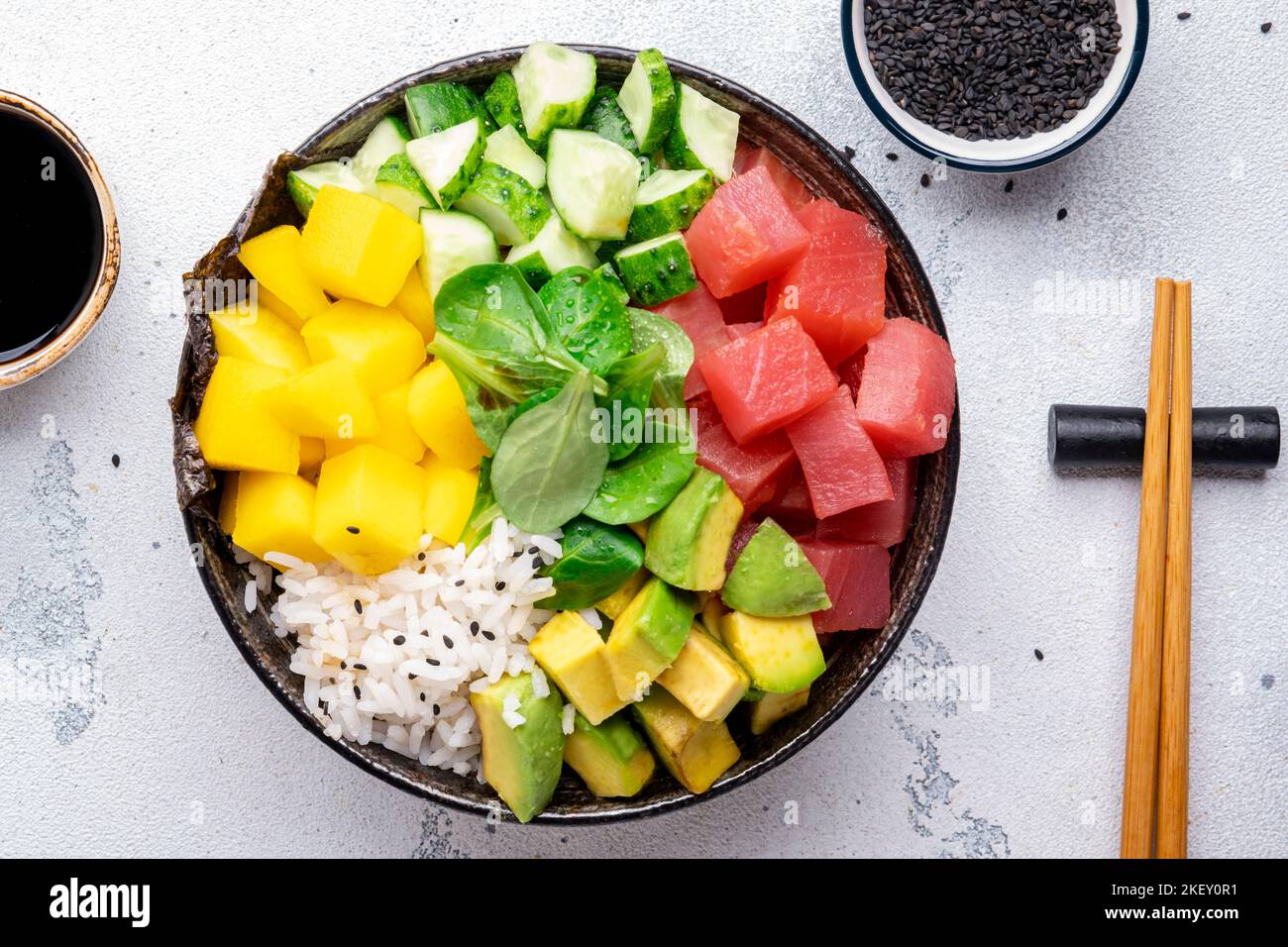 Hawaiian poke bowl. Trendy dish with tuna, avocado, mango, cucumber ...