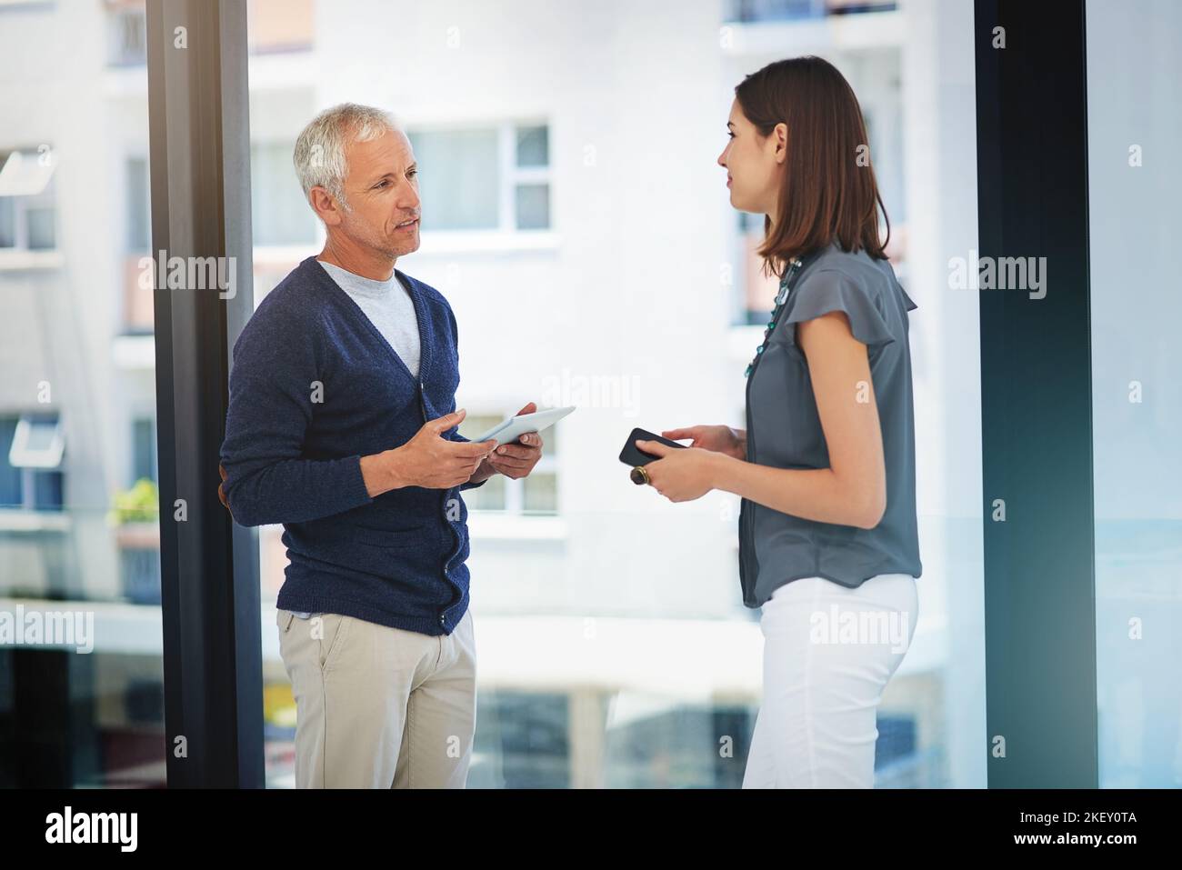 Ive been meaning to ask you...two colleagues having a conversation in their office Stock Photo ...
