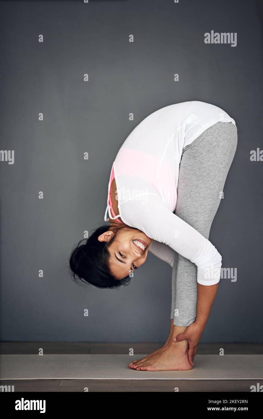 Stretch it out. a young woman stretching during her yoga routine Stock ...