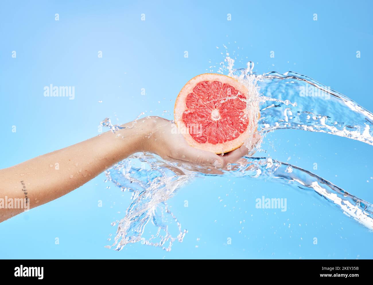 Hands, fruit and water splash for skincare wellness, cosmetics or ...