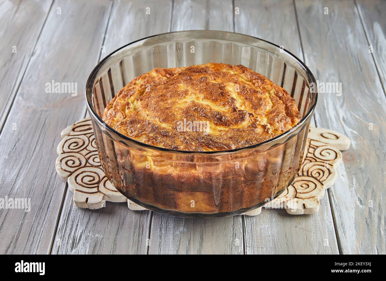 Puffed cauliflower souffle in transparent bowl on wooden background ...