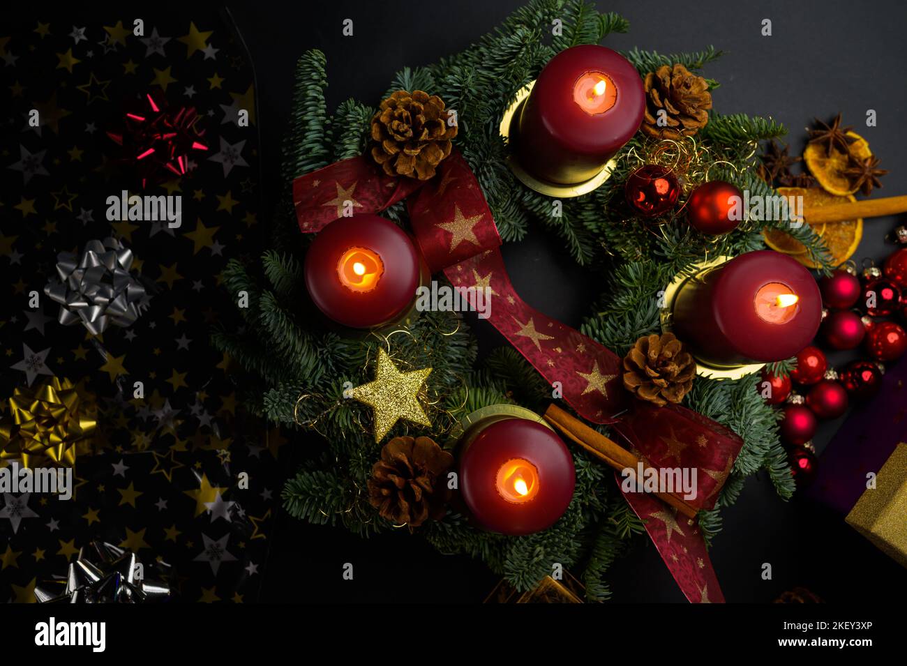 Top down view of advent wreath with lit candles surrounded by christmas ...