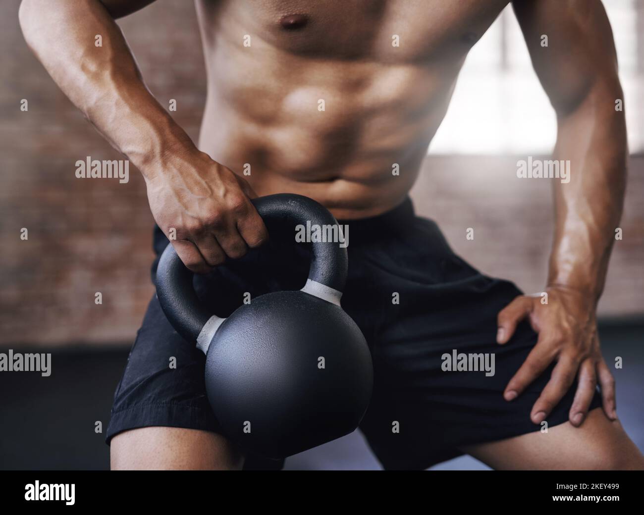 Putting a little weight on his arms. a young man working out in the gym ...