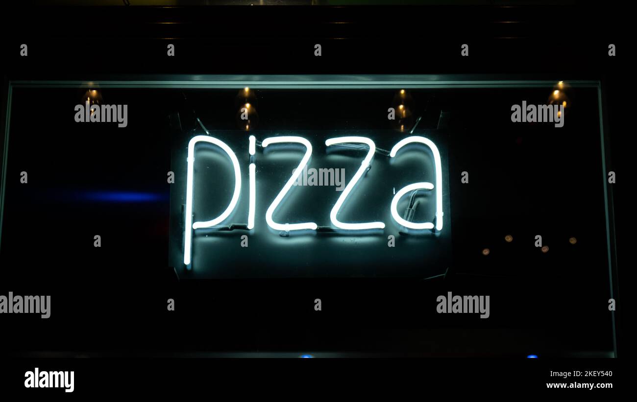 Pizza inscription in neon lights at night. Electric sign at night ...