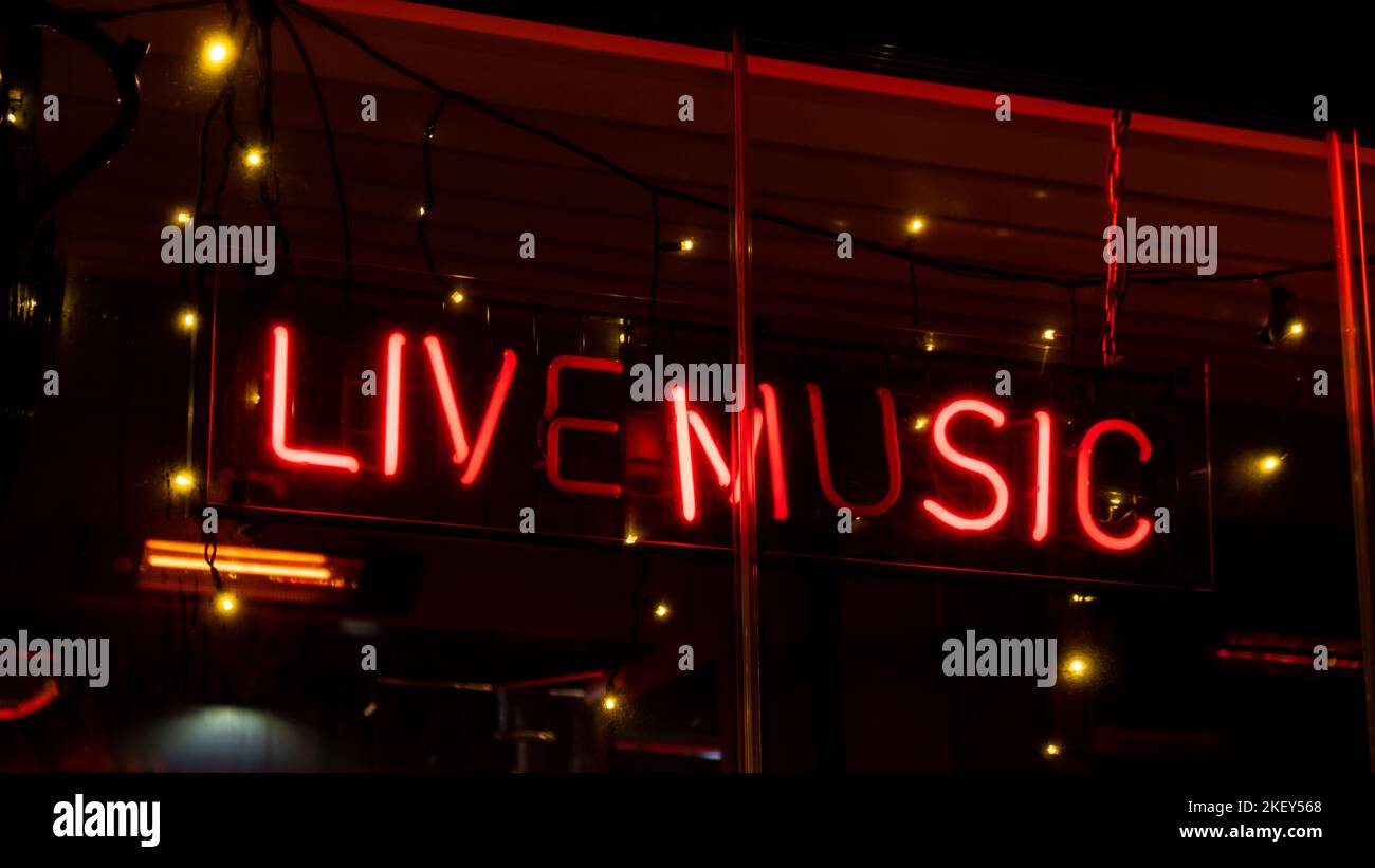 Live music inscription in neon lights at night. Electric sign at night ...