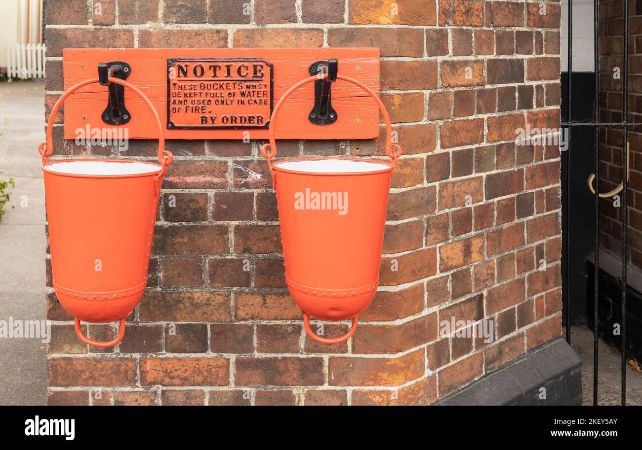 two red fire buckets hanging on a wall, vintage fire fighting equipment ...