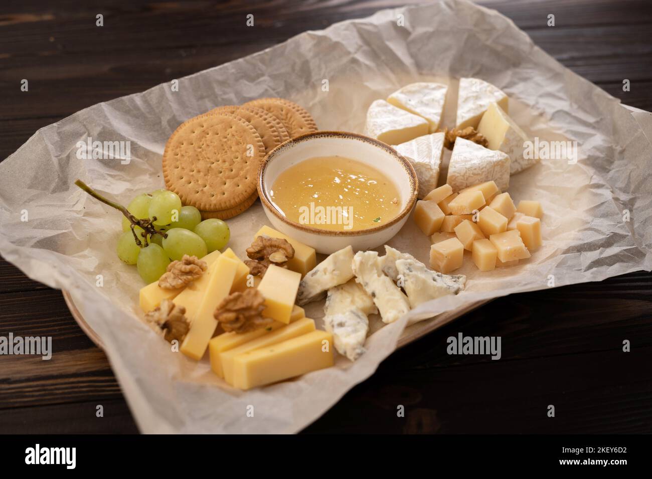 Cheese plate with honey, grapes and nuts on wooden table Stock Photo ...