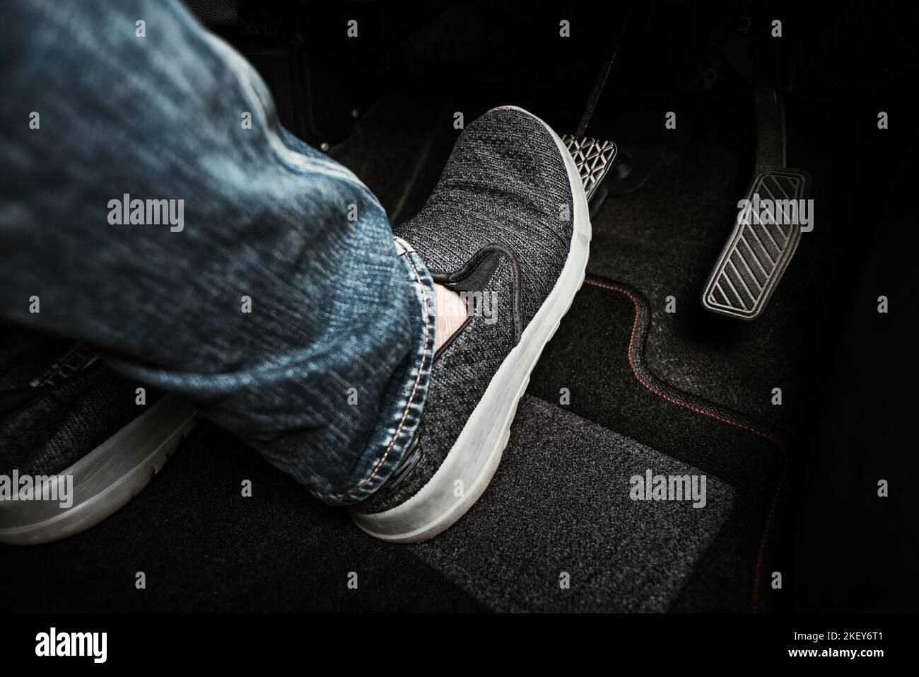 Close up the foot pressing brake pedal of a car. Driver stopping the ...