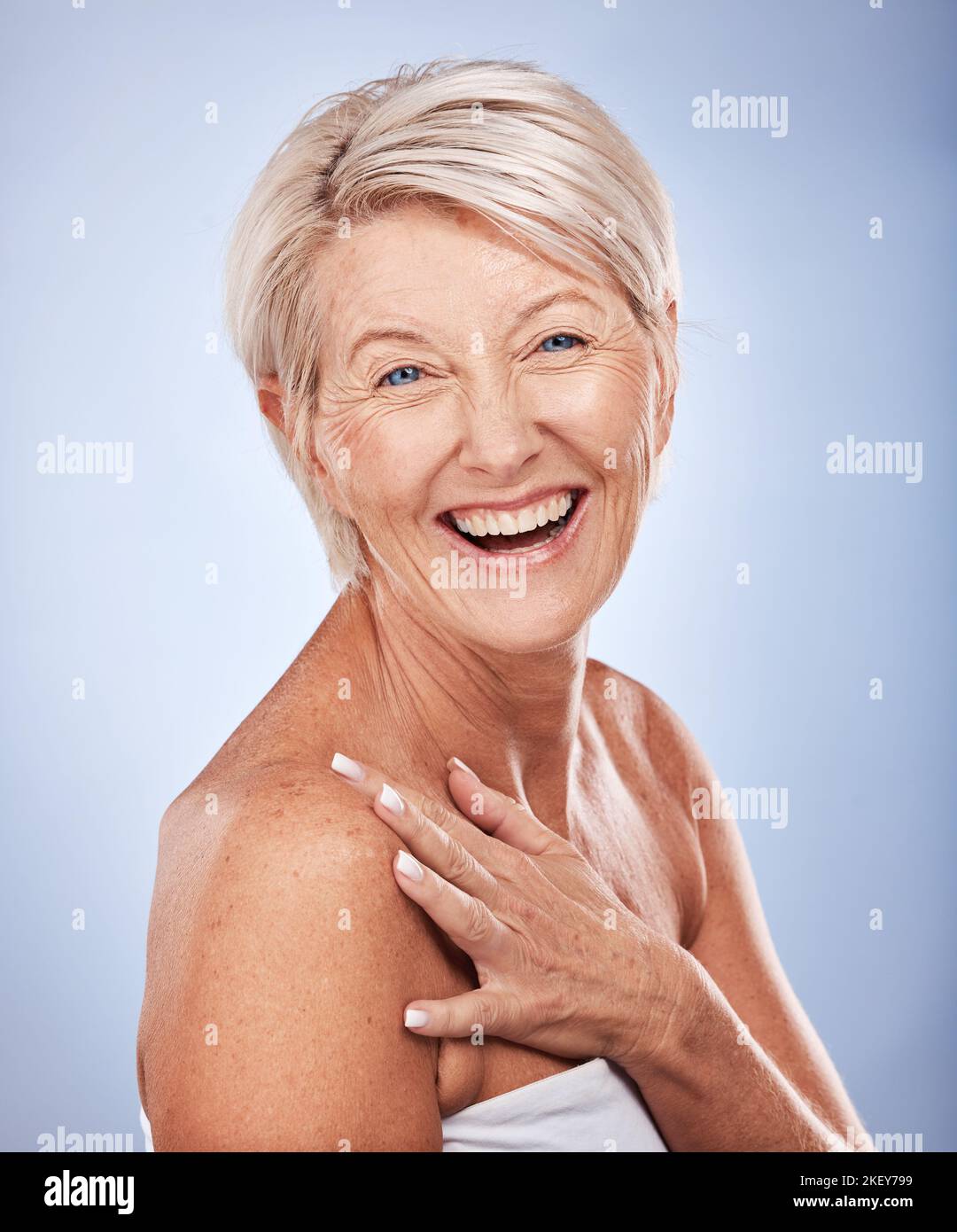 Face portrait, skincare and senior woman in studio isolated on blue ...
