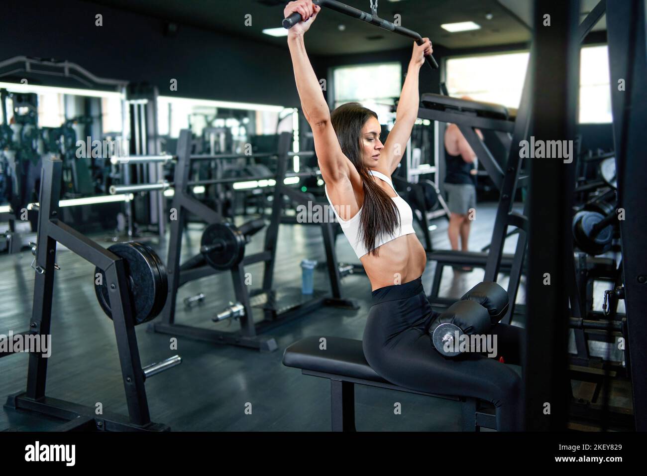 sporty woman performing a pull-up exercise on a horizontal bar Stock ...