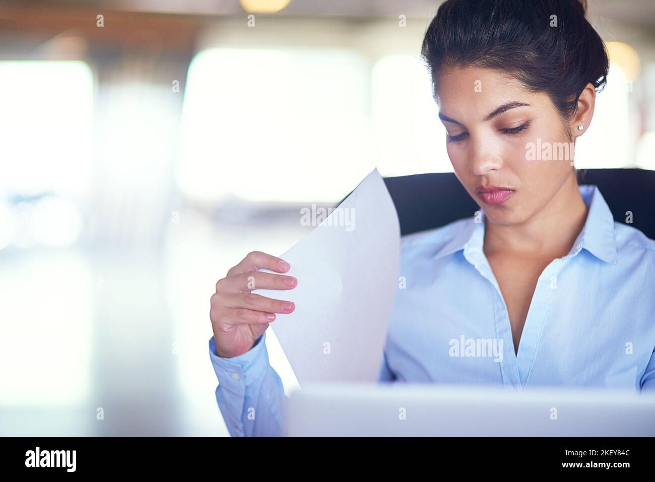 Getting some admin out of the way. a young businesswoman going over ...