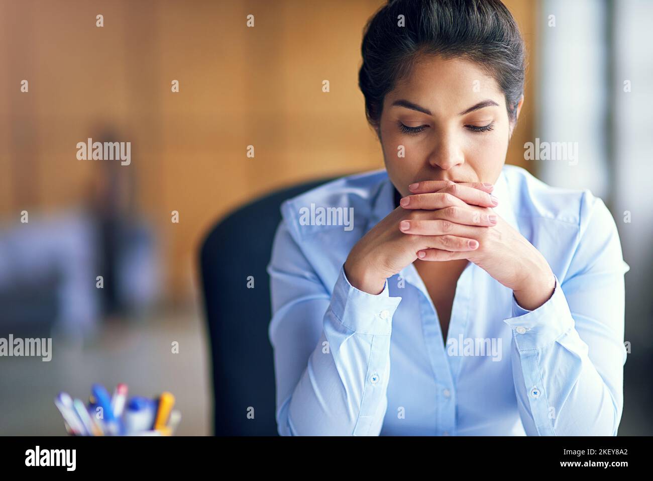 Regretting a bad business decision. a young businesswoman looking ...