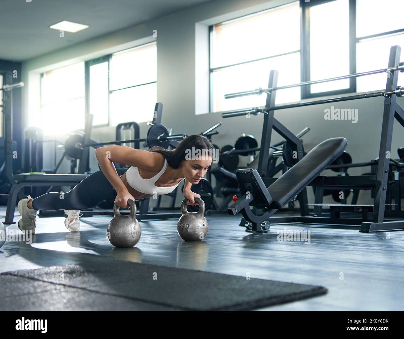 sporty woman performing an exercise on a leg simulator Stock Photo - Alamy