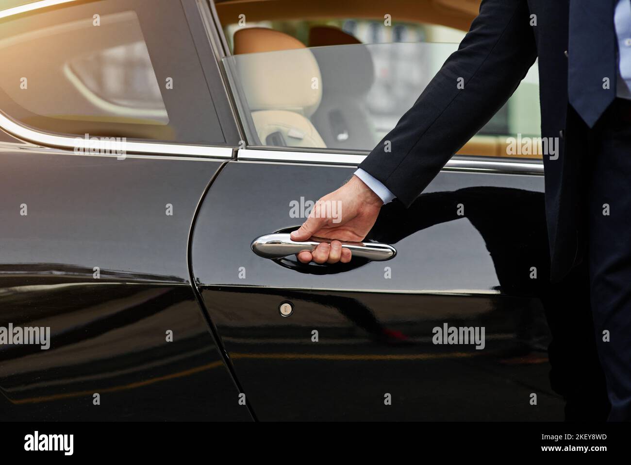 Your ride is here...an unrecognizable male chauffeur opening a car door ...