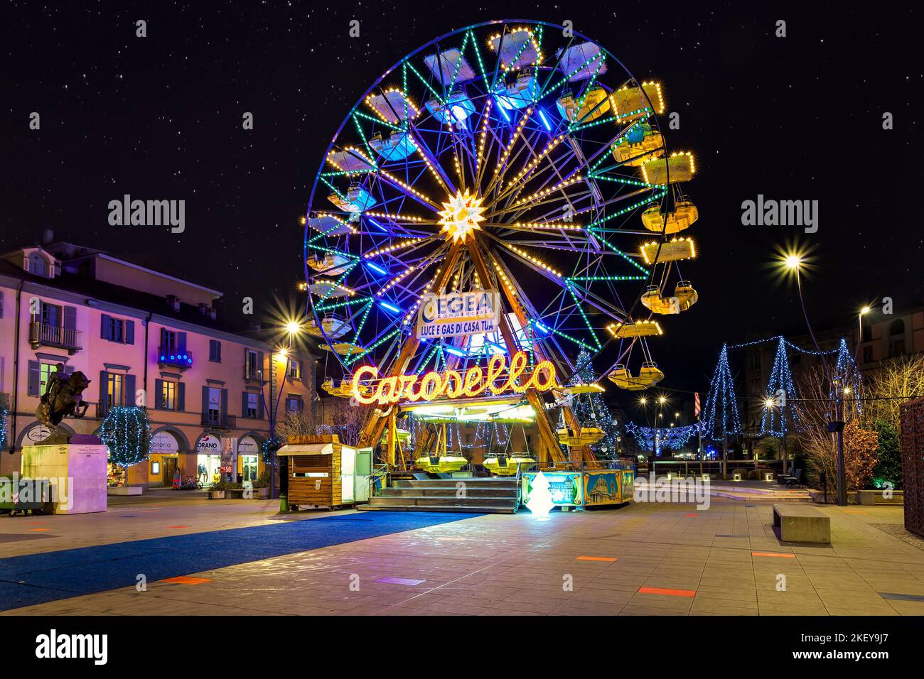 Illuminated Ferris Wheel under the sky with stars on town square during ...