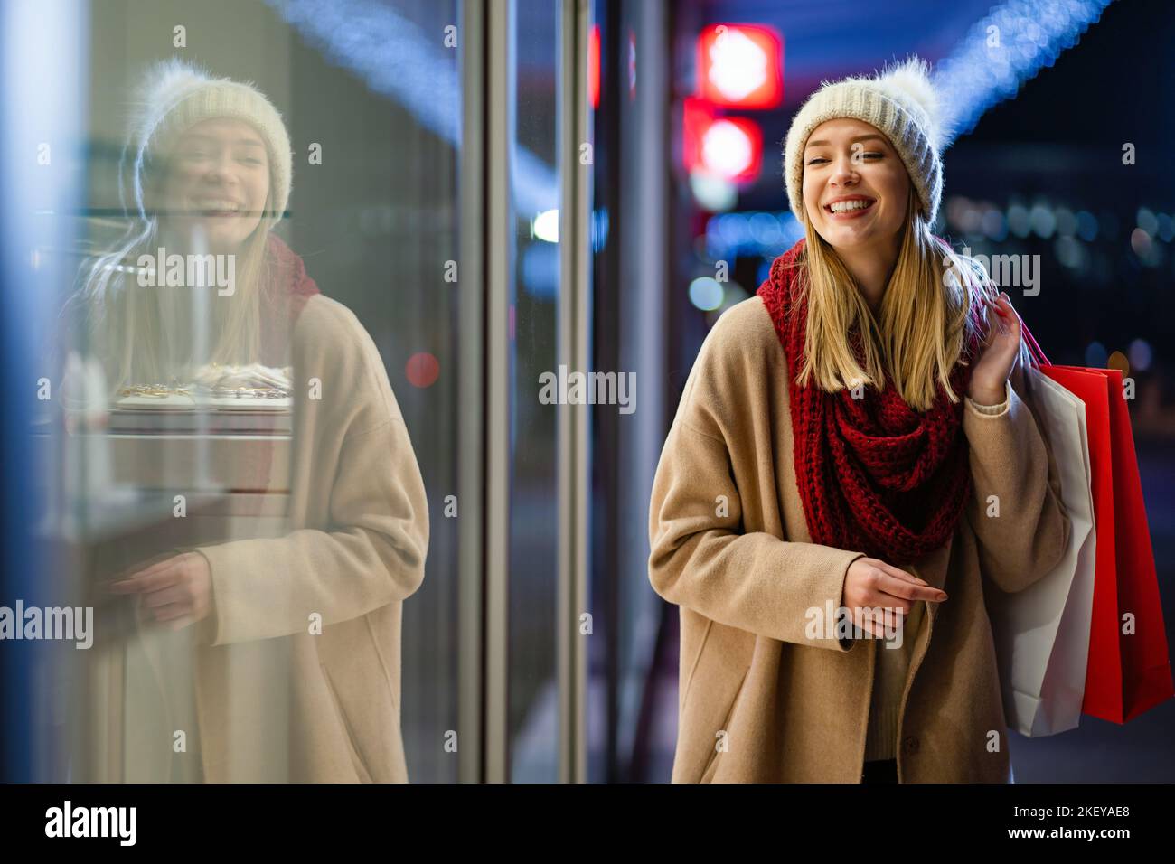 Portrait of happy woman spending time with christmas shopping outdoors ...